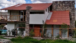 Um edifício de dois andares com fachada de pedra e telhado de telhas vermelhas.