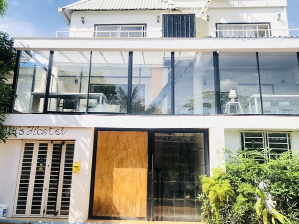 Um edifício de dois andares com uma placa que diz 'Abi's Hostel'.