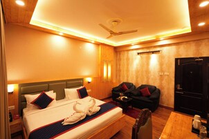 Quarto de hotel com uma cama, um sofá, uma mesa e uma porta.