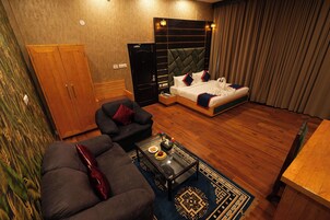 Quarto de hotel moderno com uma cama, um sofá, uma mesa de centro e um guarda-roupa.