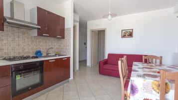 Apartamento, 1 quarto | Cozinha privada | Geladeira grande, fogão, cooktop, talheres/pratos/utensílios de cozinha