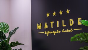 Uma parede com o texto "MATILDE lifestyle hotel" e três estrelas acima.