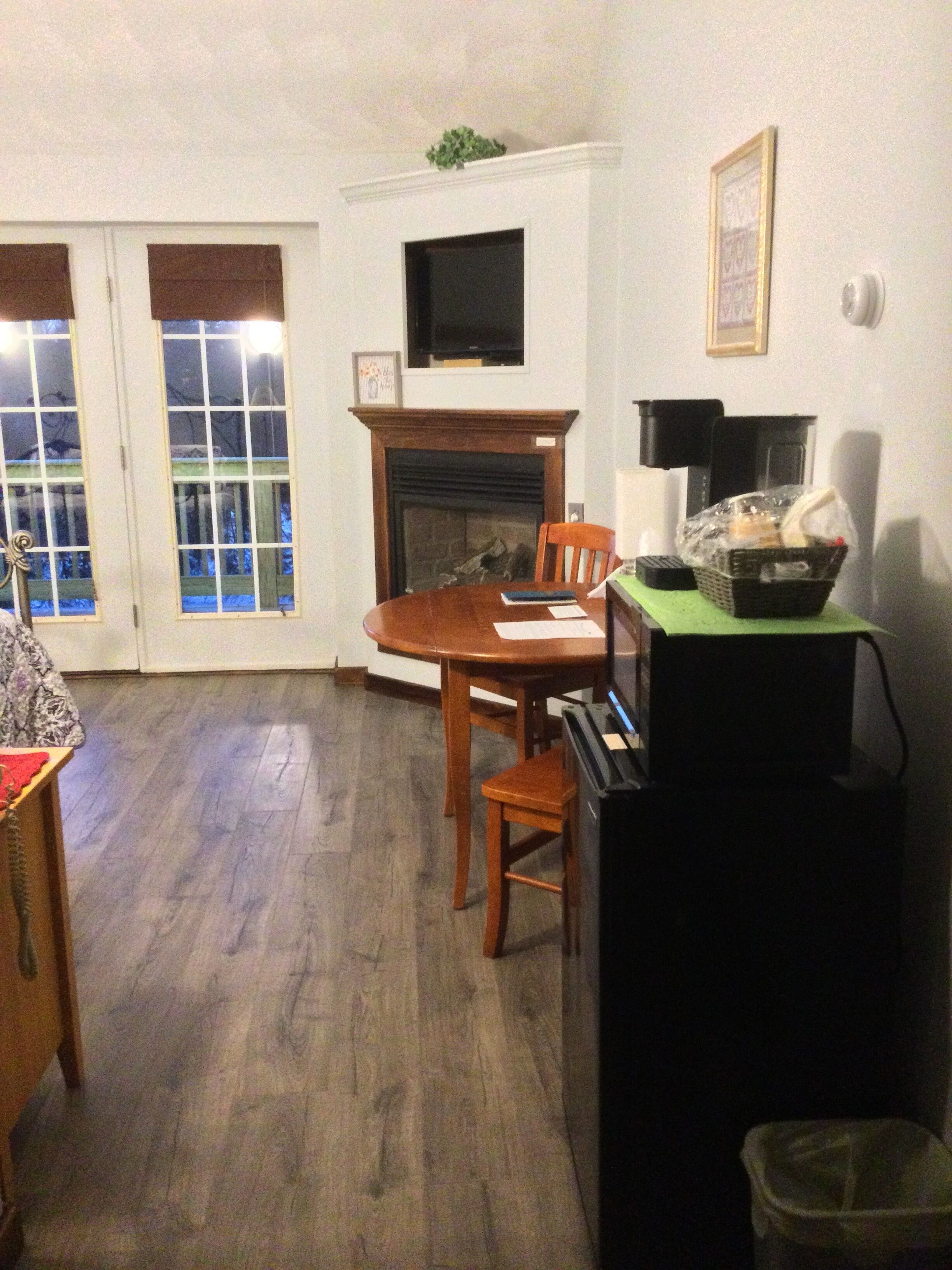Uma sala de jantar com lareira, piano e cafeteira.