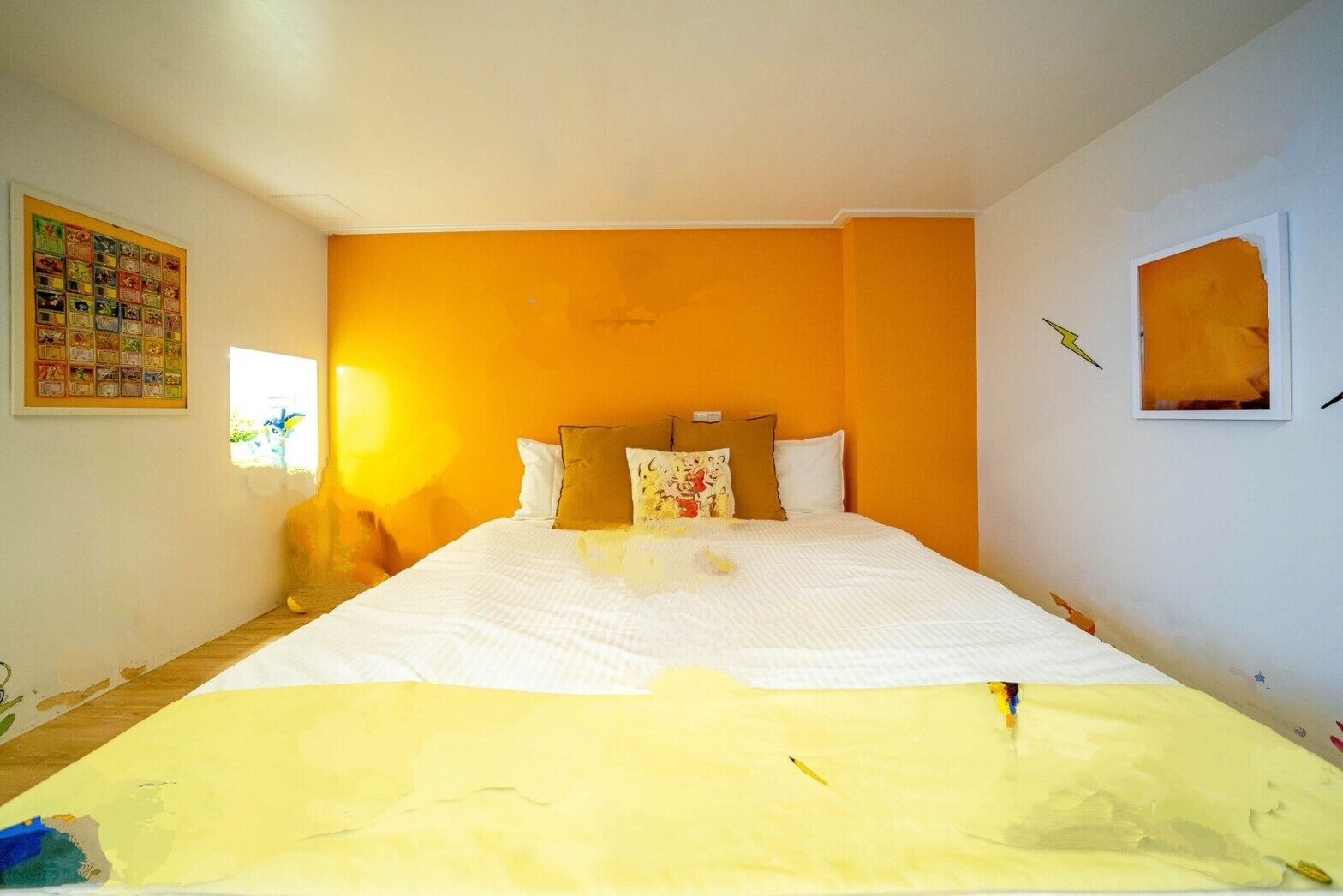 Quarto com cama grande, paredes alaranjadas e janela com vista.