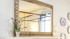Uma lareira com revestimento de azulejos, um espelho acima e pratos decorativos na parede.