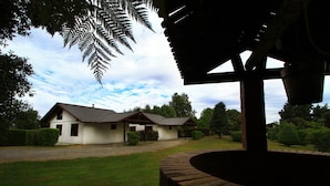 Uma casa com varanda coberta e gramado bem cuidado.