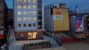 Um edifício de vários andares com uma placa grande 'GINGER' no topo.