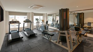 Uma academia com esteiras, elípticos e equipamentos de musculação.