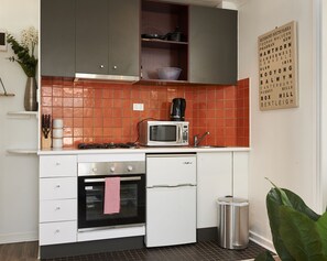 Apartamento Deluxe, 1 quarto | Cozinha privada | Um frigorífico, um micro-ondas, um forno, uma placa de cozinha 
