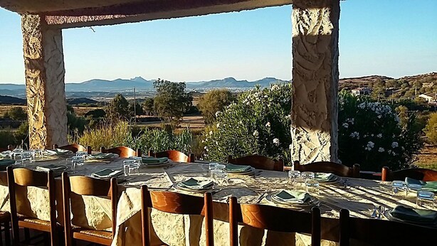 Mesa posta para refeição com vista para o campo.
