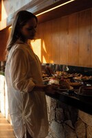 Uma pessoa em frente a um buffet com diversos pratos.
