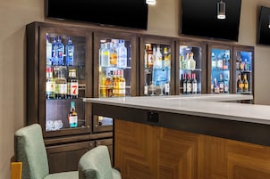 Uma área de bar com vários armários para bebidas e um balcão.