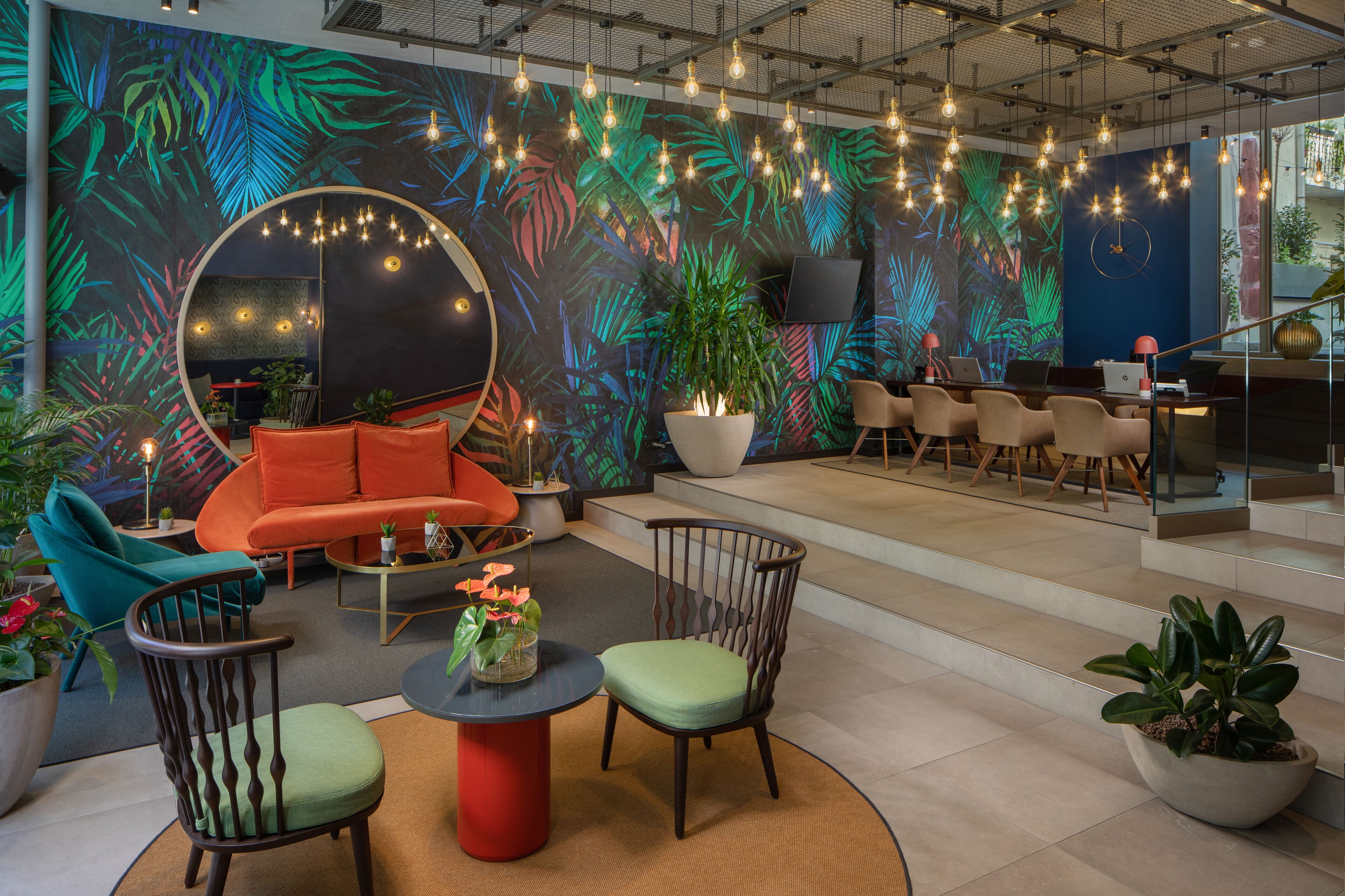 Uma área de estar moderna com um mural tropical vibrante, assentos confortáveis e iluminação suave.