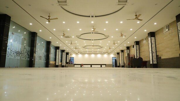 Um hall amplo com piso brilhante, várias ventoinhas no teto e iluminação embutida.