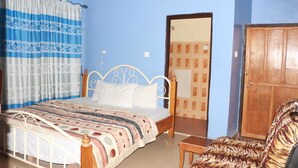 Quarto com cama, uma cadeira e um guarda-roupa.