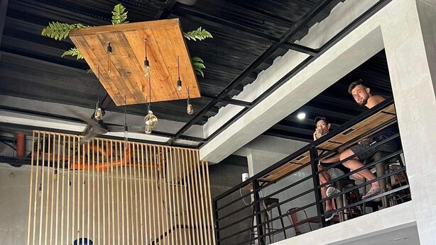 Um interior moderno com escada, teto de madeira e área de bar.