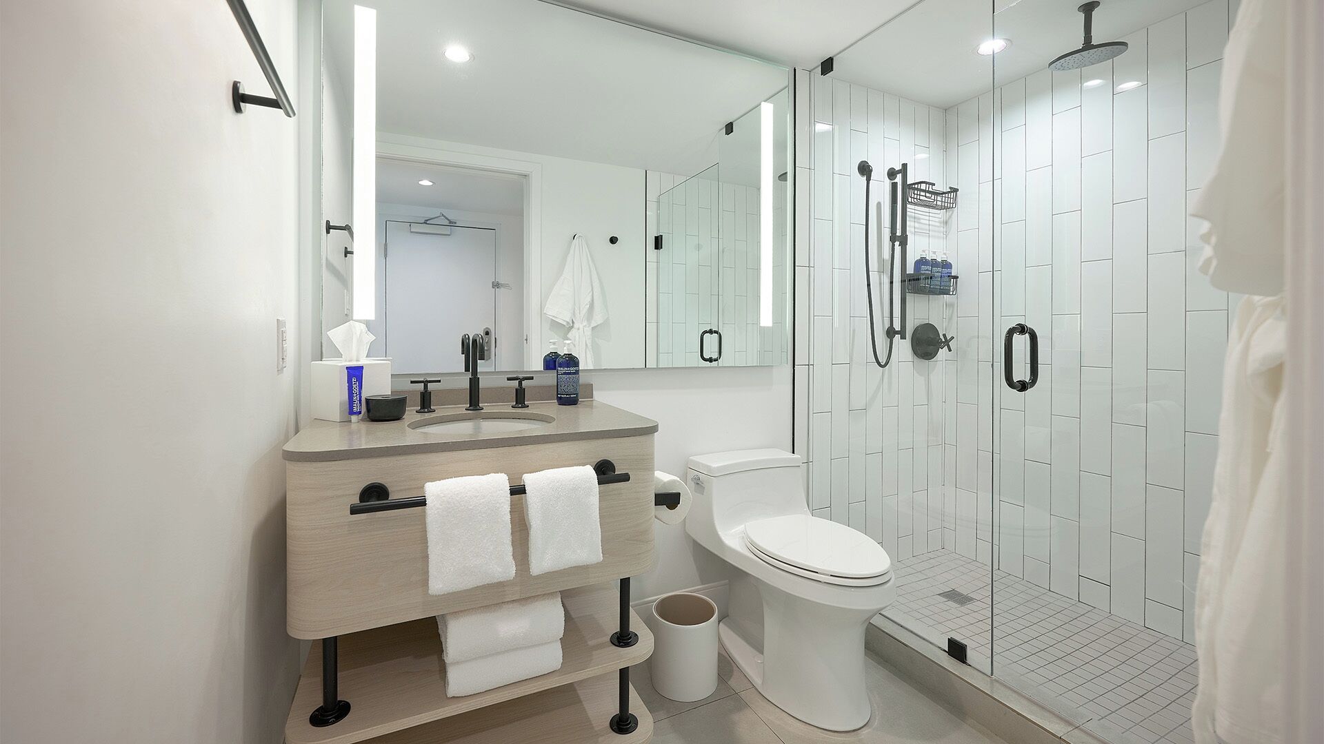 Uma casa de banho moderna com sanita, lavatório e chuveiro.