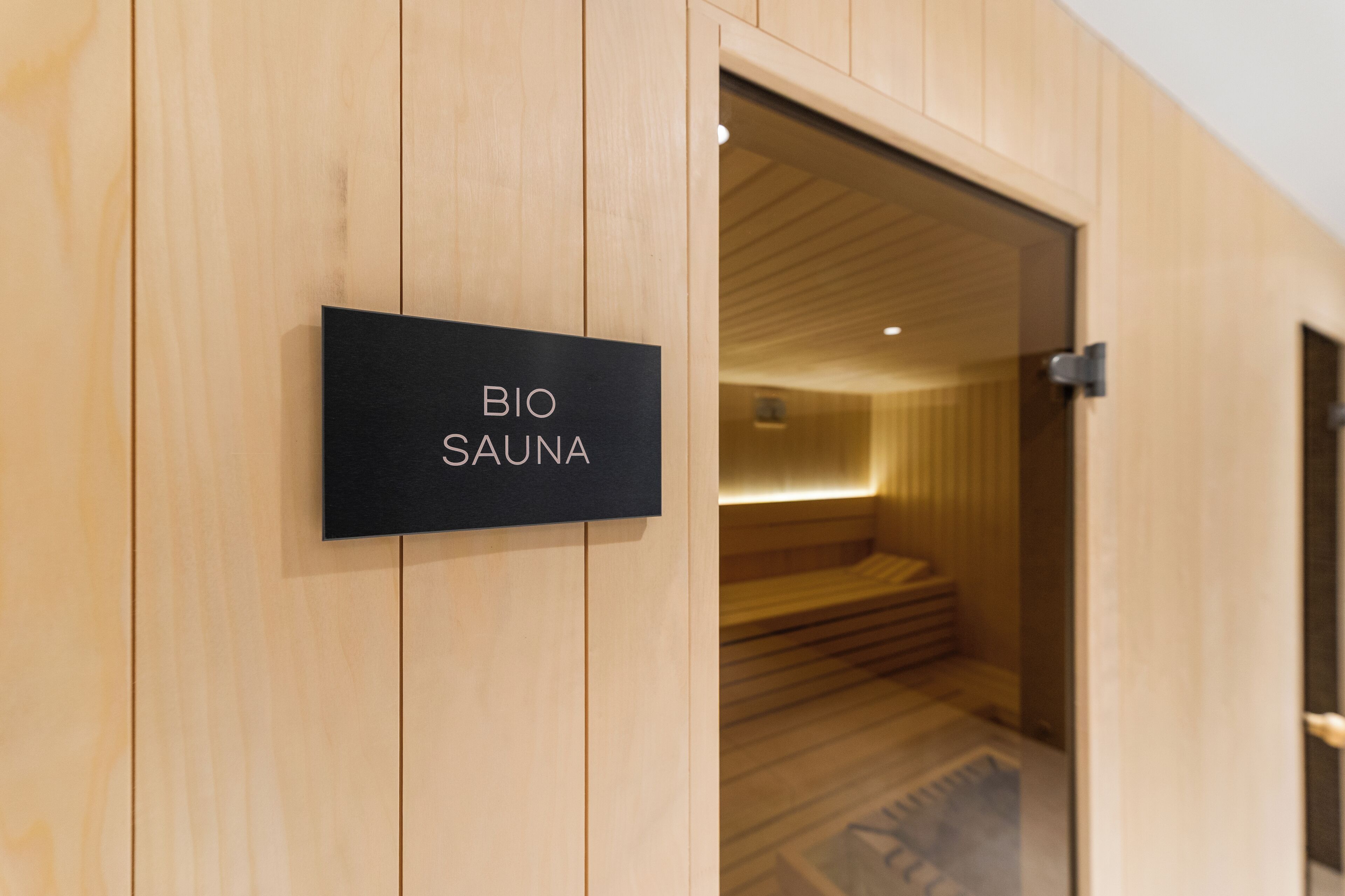 Parede de madeira com uma placa que diz 'BIO SAUNA'.