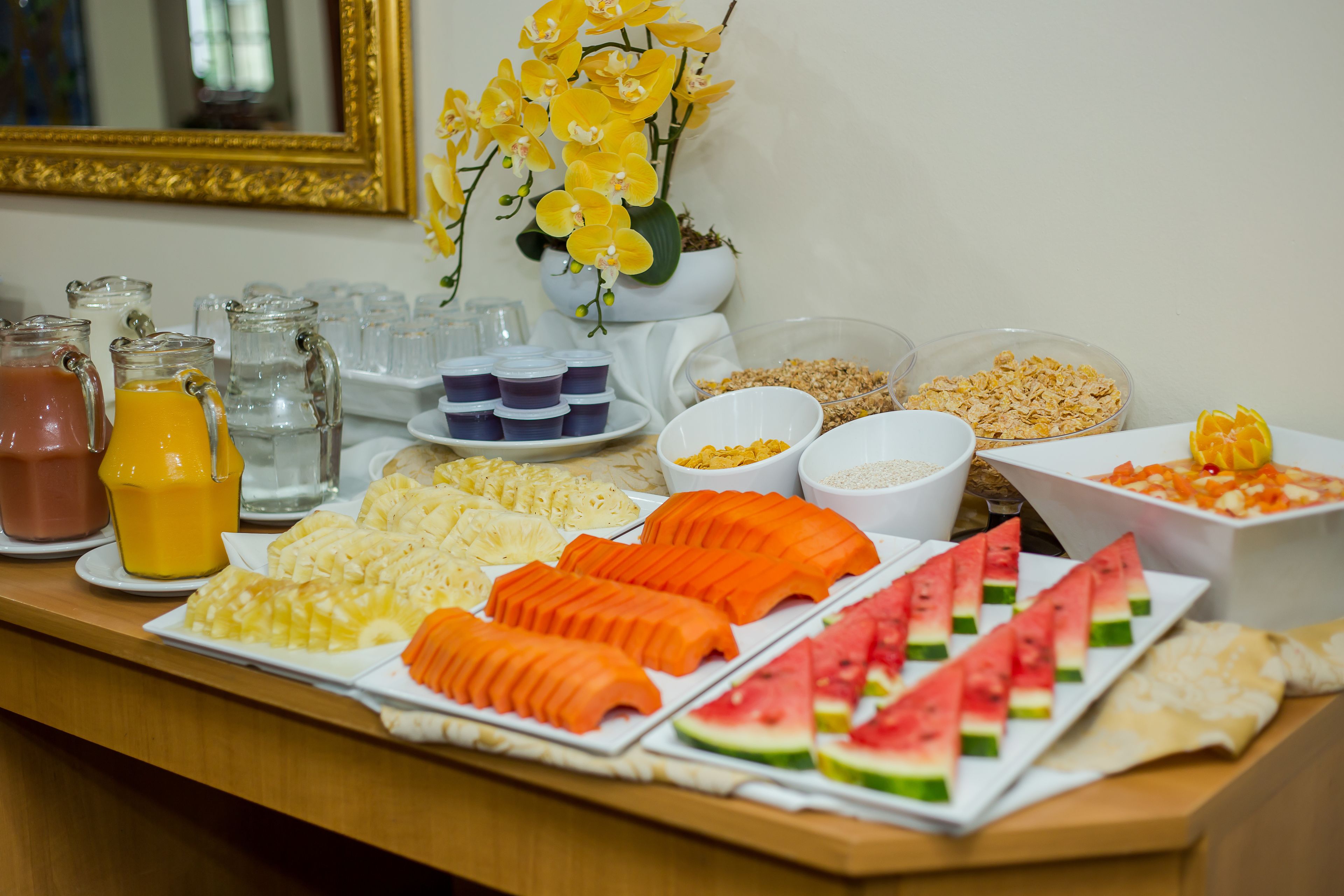 Uma mesa de buffet com diversos alimentos e bebidas.