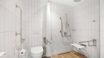 Uma casa de banho moderna com azulejos brancos, chuveiro, sanita e lavatório.