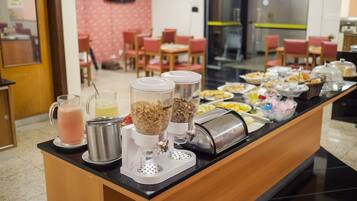 Um balcão de buffet com diversos alimentos e uma estação de café.