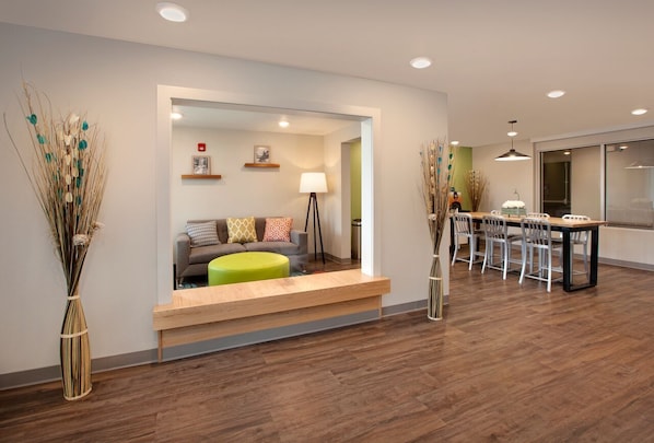 Uma sala de estar moderna com sofá, mesa de centro e área de jantar com cadeiras.