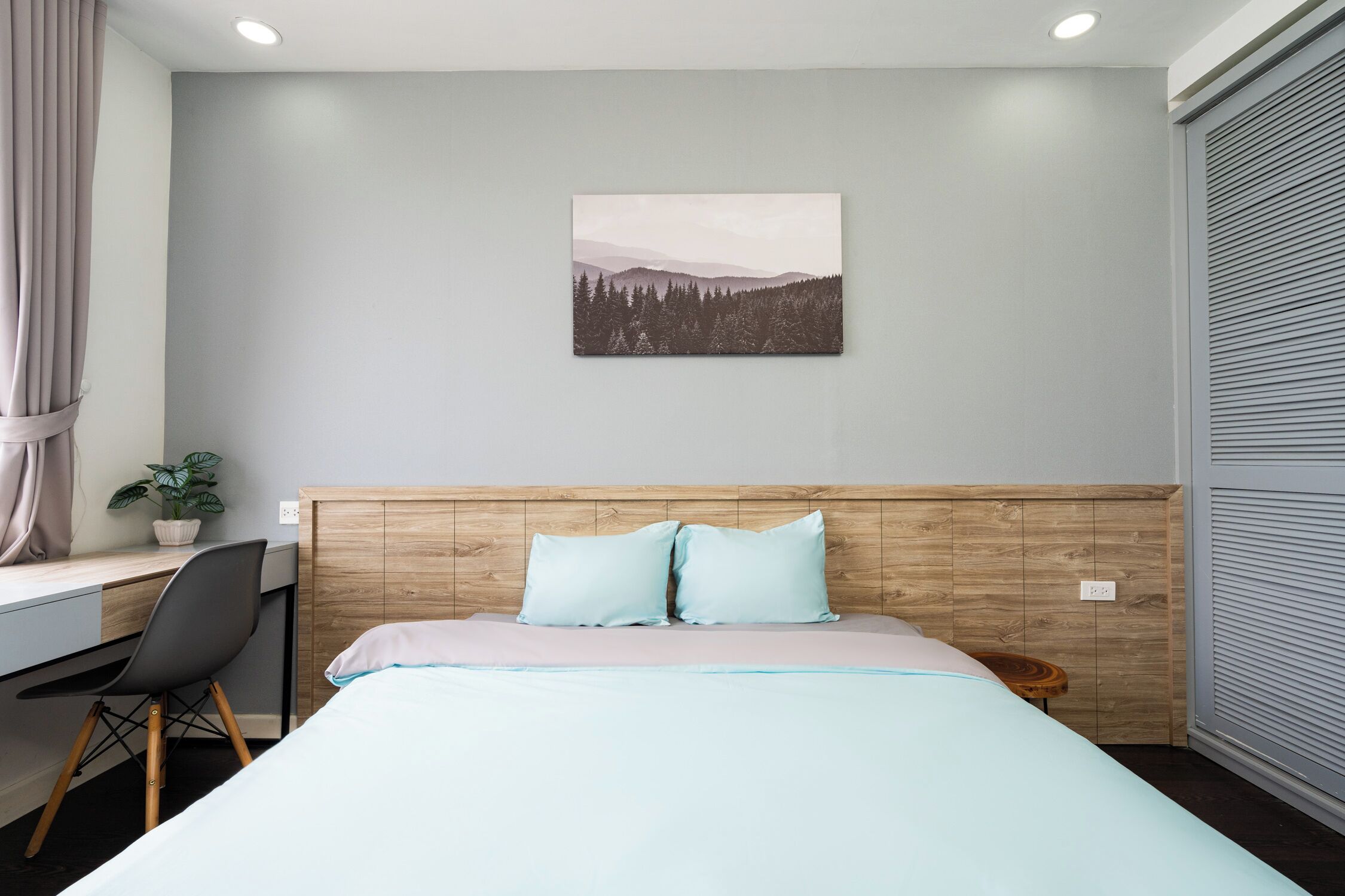 Quarto com cama, escrivaninha e cadeira.