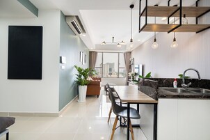 Cozinha moderna com área de refeições, janelas amplas e vista para a cidade.