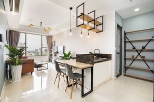 Cozinha moderna com área de refeições, janelas amplas e vista para a cidade.