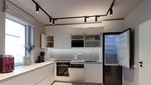Cozinha moderna com eletrodomésticos embutidos, máquina de lavar louça e frigorífico com congelador.