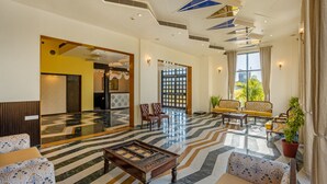 Um hall amplo com design moderno, com piso estampado, assentos confortáveis e uma grande janela com vista para o exterior.