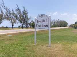 Placa para a Rose Hall Great House com vista clara da paisagem ao redor.
