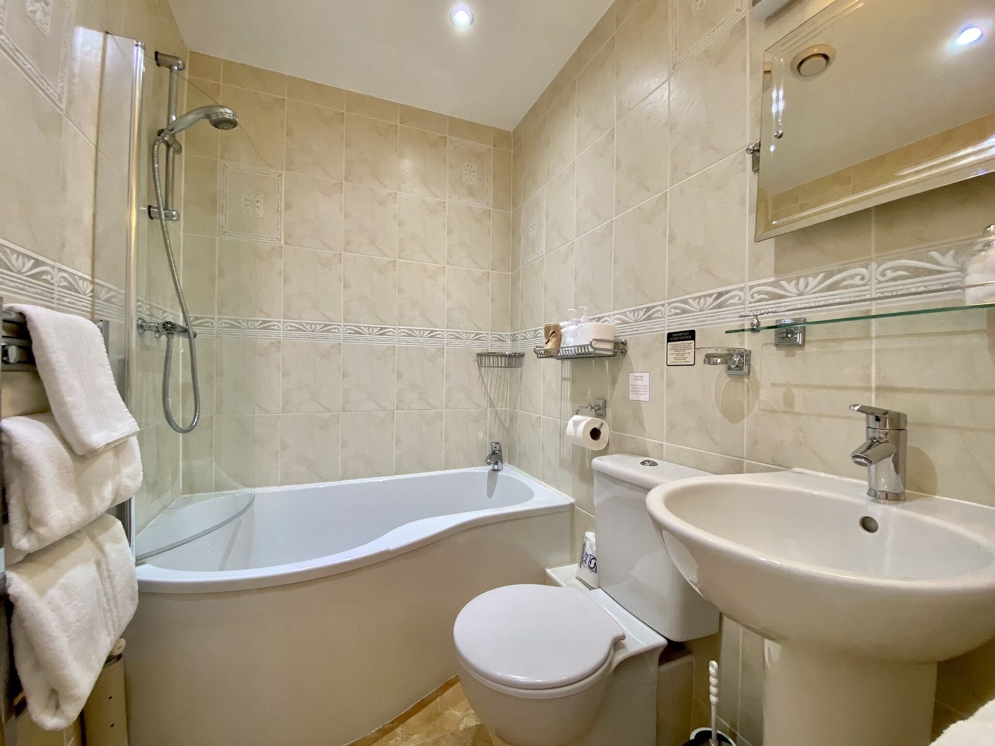 Uma casa de banho moderna com banheira, sanita e lavatório.