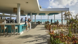 Bar de resort com área externa e vista para o oceano.