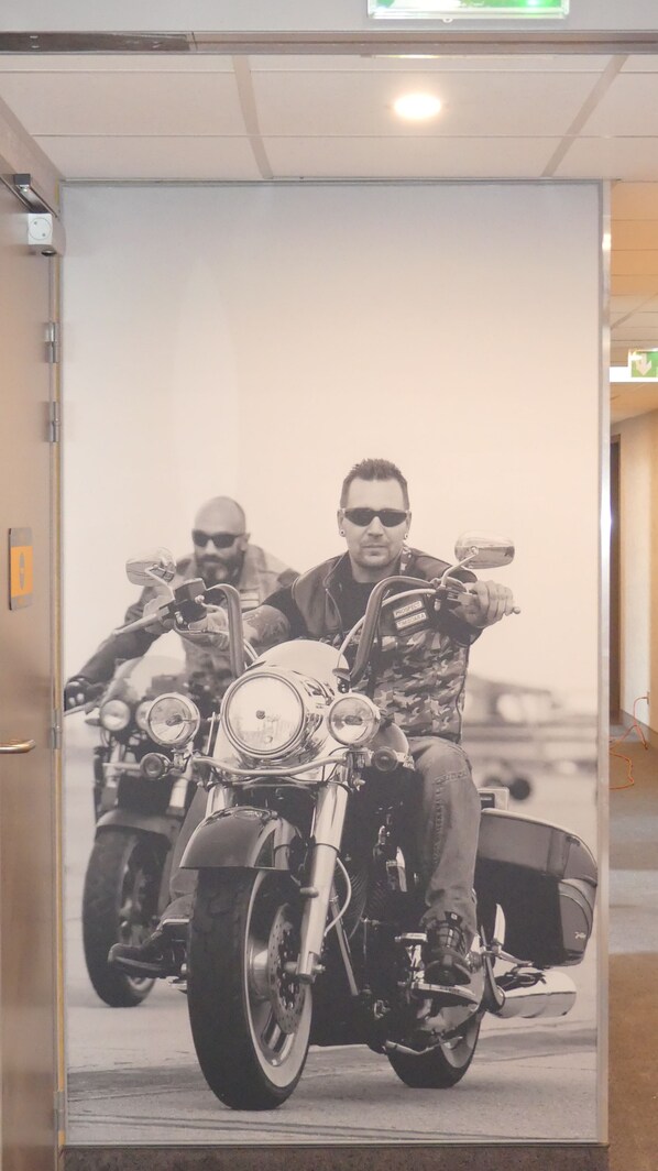 Um cartaz de dois homens em motocicletas, com uma etiqueta de nome que diz 'PROSPECT THOMPSON'.