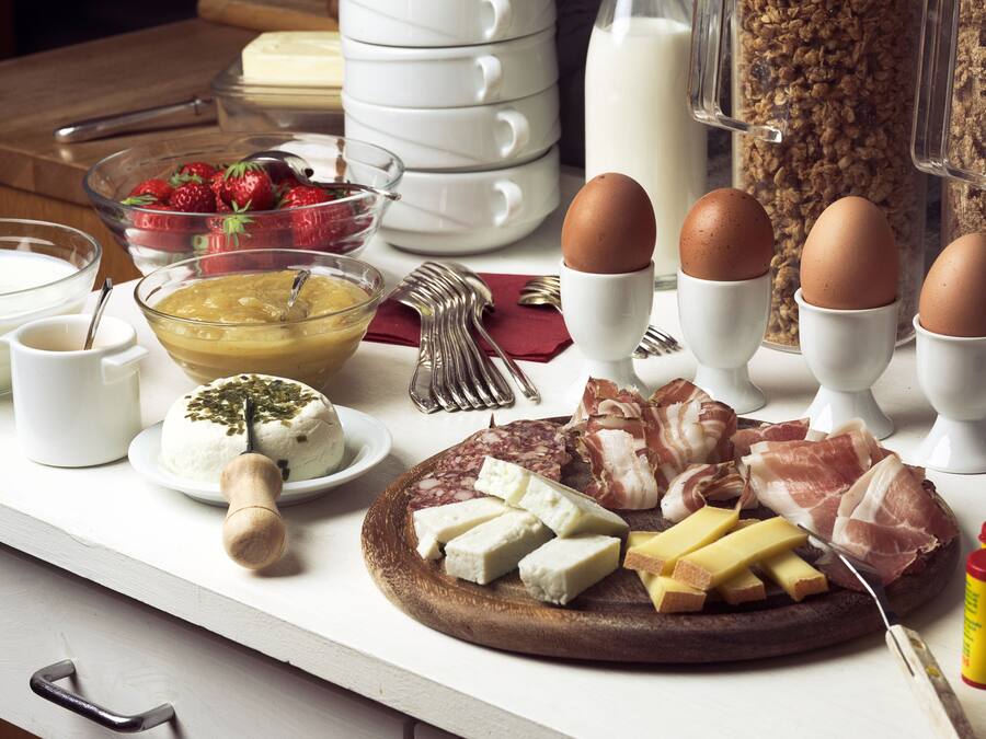 Uma mesa de café da manhã com diversos alimentos e utensílios.