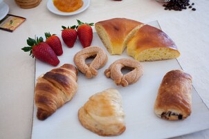 Diversos doces e frutas sobre uma mesa.