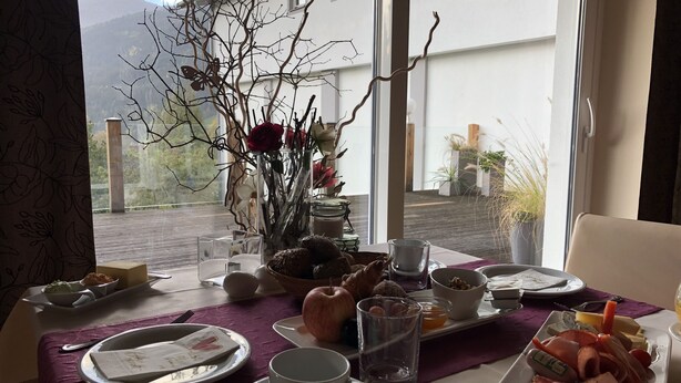 Uma mesa de café da manhã com pratos, xícaras e diversos alimentos.