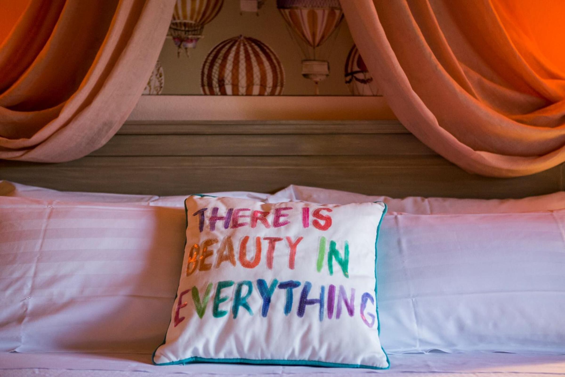 Uma cama com um travesseiro que diz: "Há beleza em tudo."