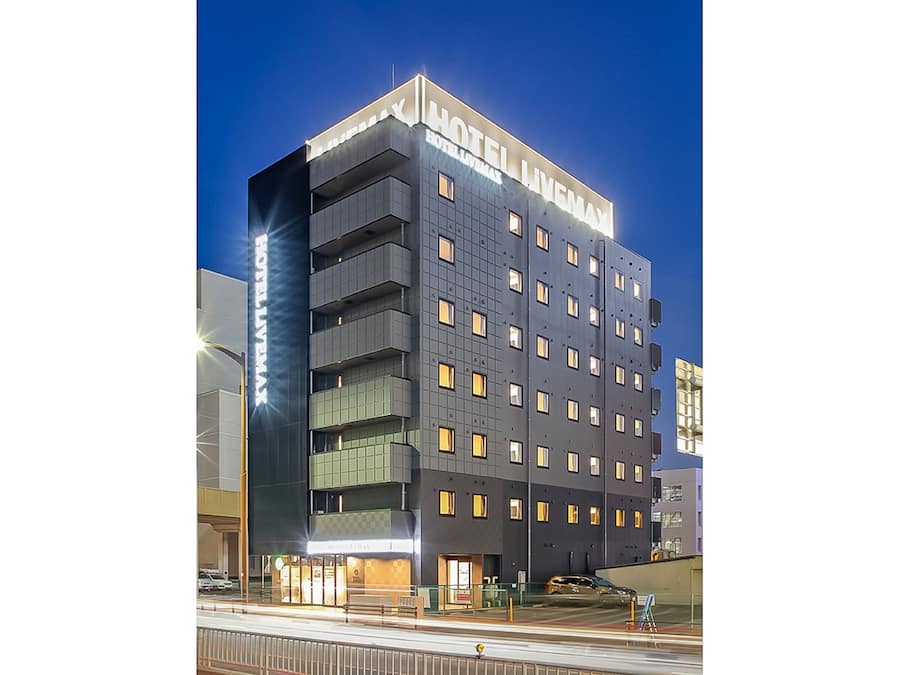 Um hotel moderno com vários andares, varandas e uma placa chamativa.