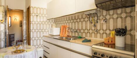 Uma cozinha com fogão, pia e painel decorativo.