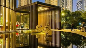 Um edifício moderno com fachada de vidro e uma piscina refletora.