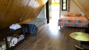 Um quarto de sótão pequeno e acolhedor, com uma cama, uma mesinha e uma cadeira.