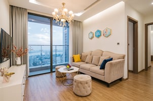 Uma sala de estar moderna com uma janela ampla, um sofá, uma mesa de centro e um candelabro.