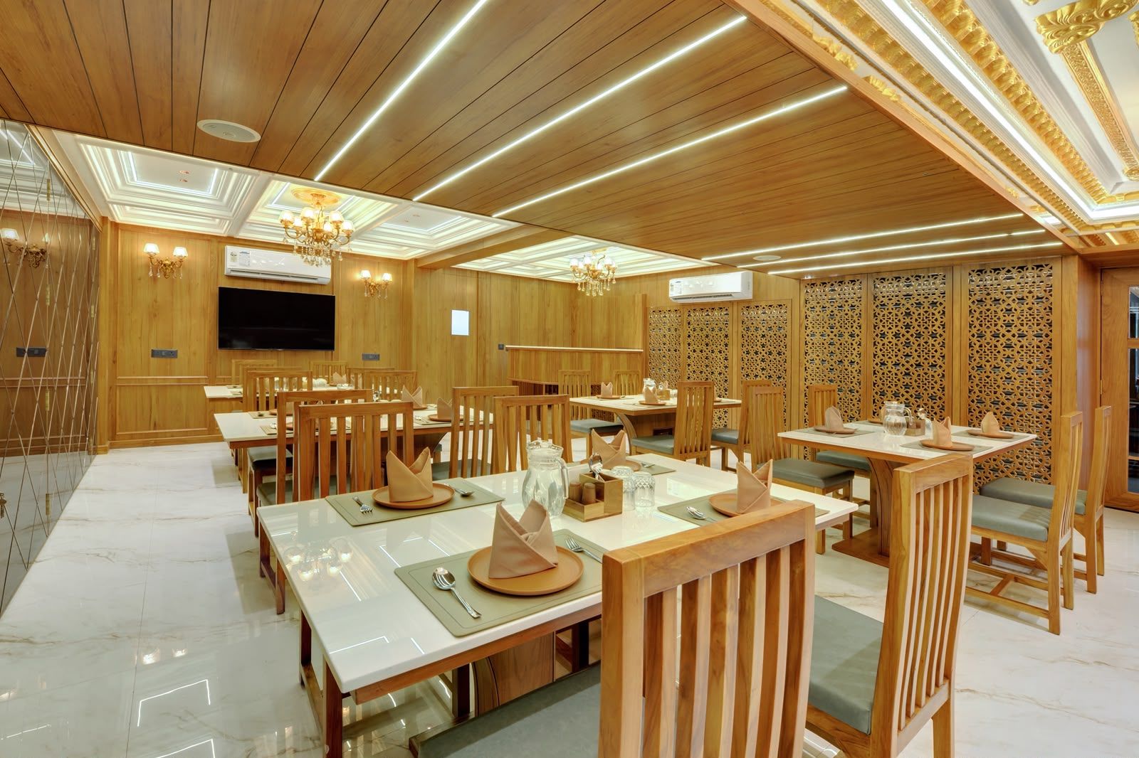 Uma sala de jantar com móveis de madeira, mesas postas com pratos e um candelabro.
