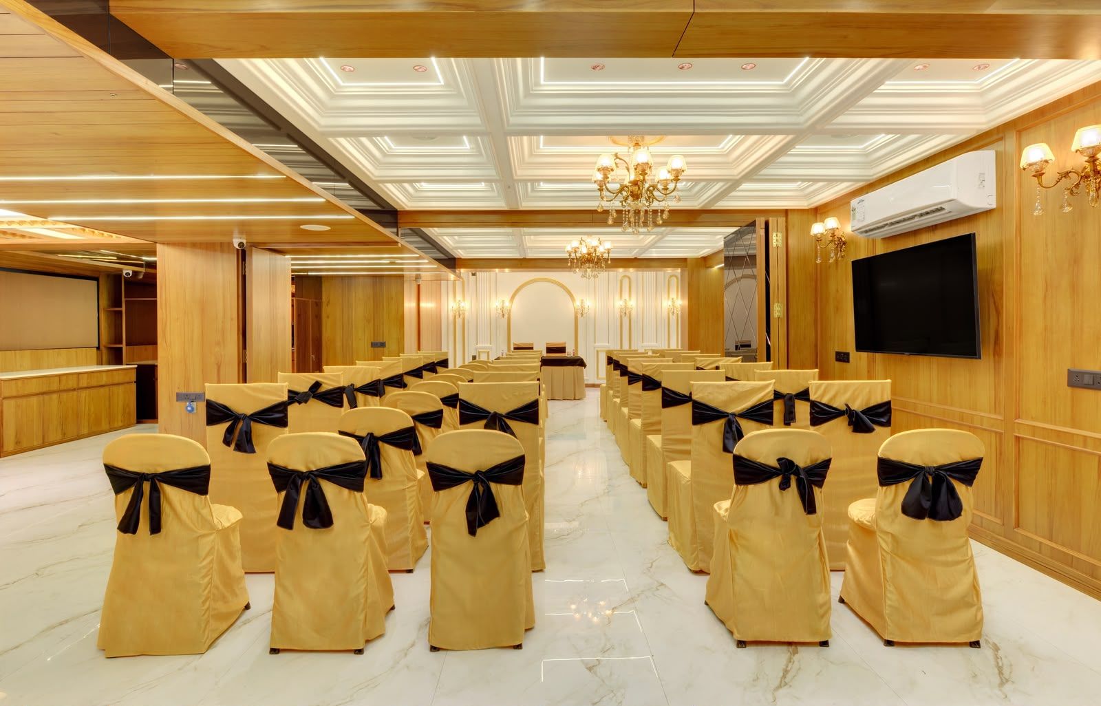 Uma sala de conferências com fileiras de cadeiras, um púlpito e uma tela grande.