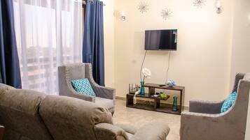 Apartamento superluxo, 2 quartos | Sala de estar | TV de tela plana