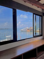Quarto com grandes janelas com vista para uma marina cheia de barcos e iates.