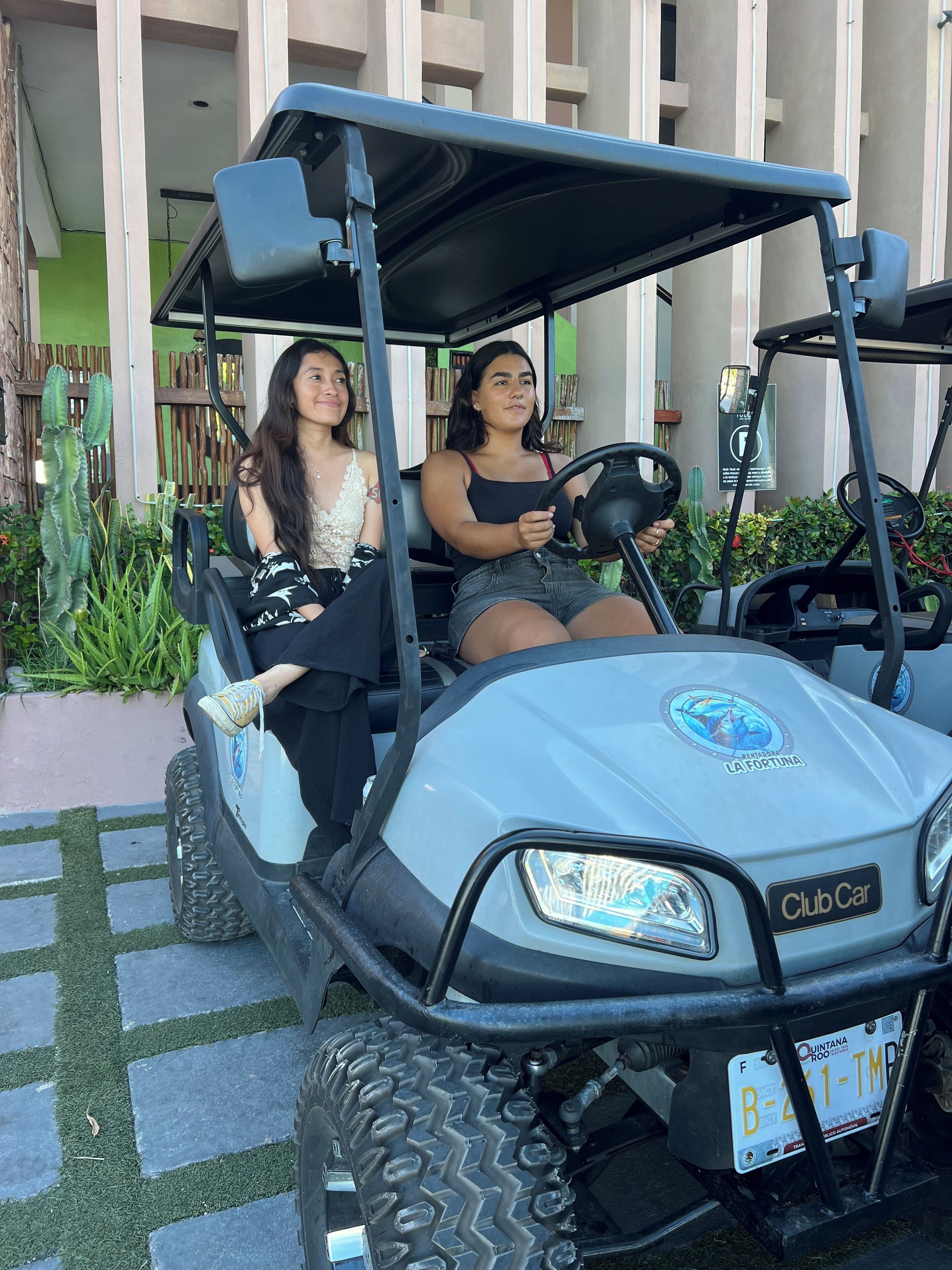 Um carrinho de golfe Club Car com dois passageiros.