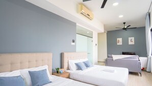 Quarto de hotel com duas camas, um ventilador de teto, ar condicionado e televisão.